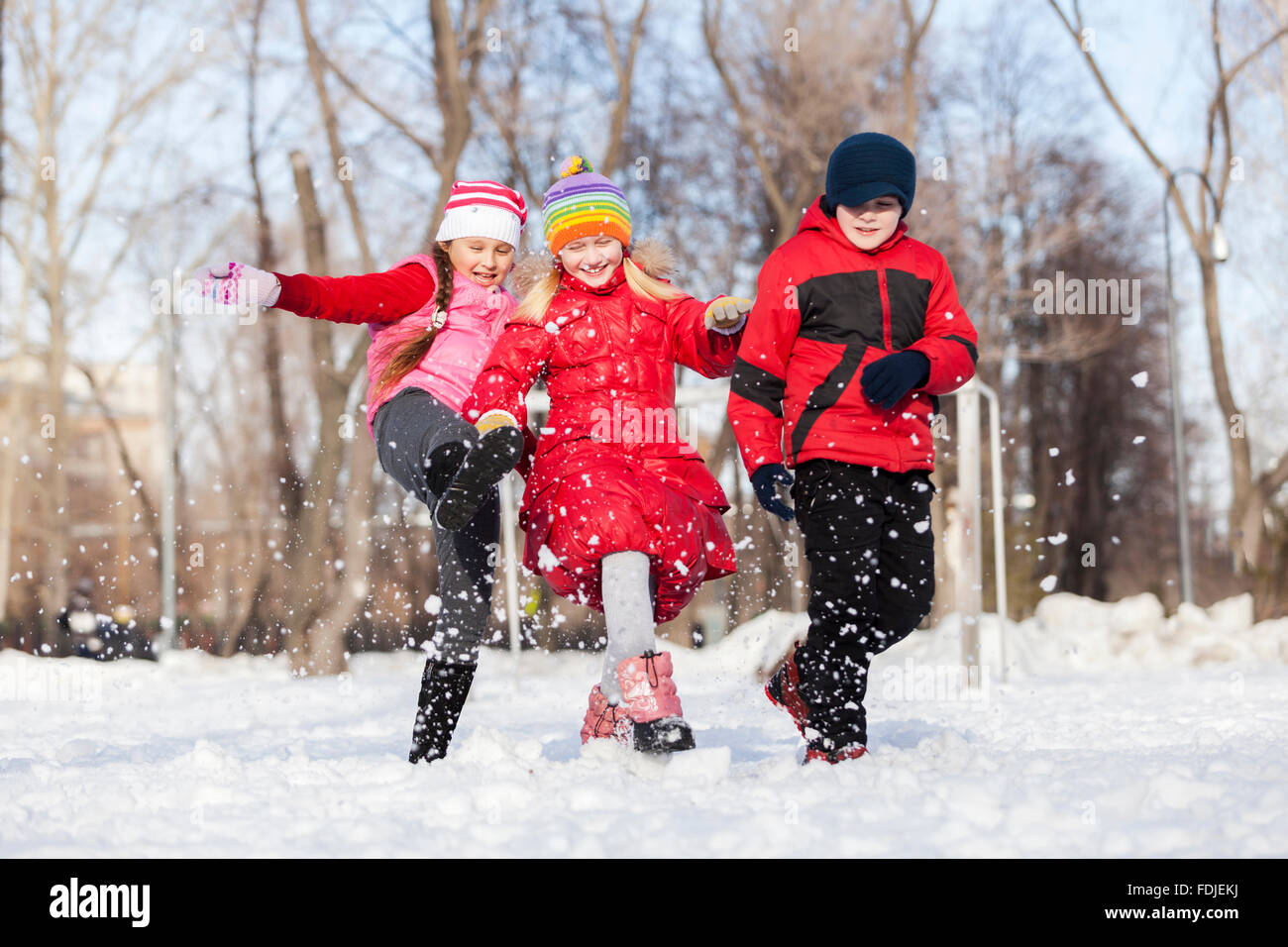 Cute children jumping and having fun in winter park Stock Photo - Alamy