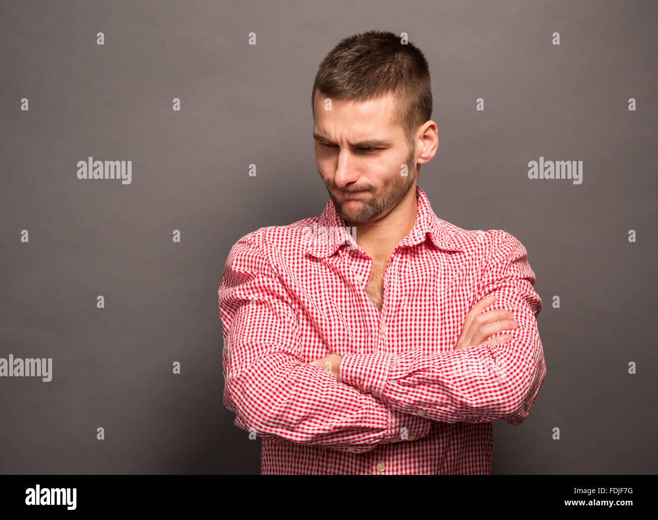 Man posing with crossed arms in studio Stock Photo - Alamy