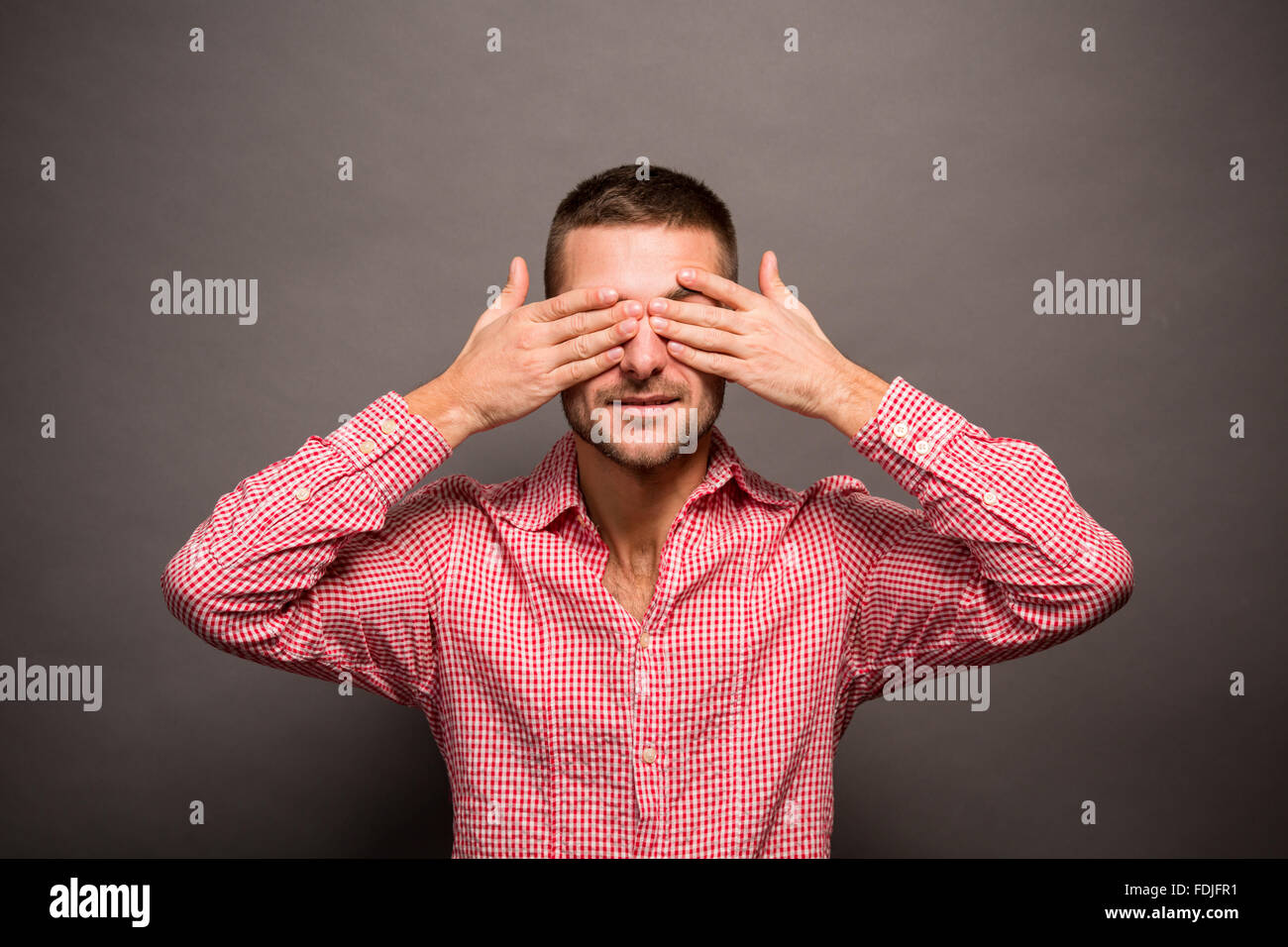 Man covering eyes with hands Stock Photo - Alamy