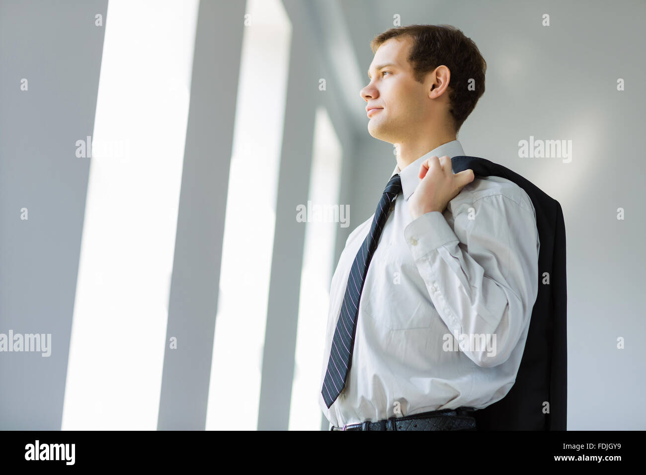 Handsome smiling businessman holding jacket on his shoulder Stock Photo ...