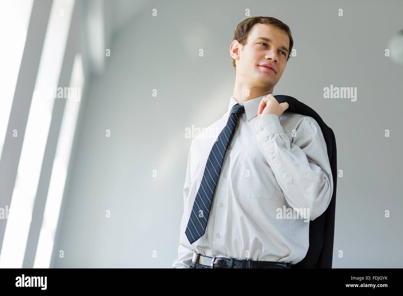 Handsome smiling businessman holding jacket on his shoulder Stock Photo ...