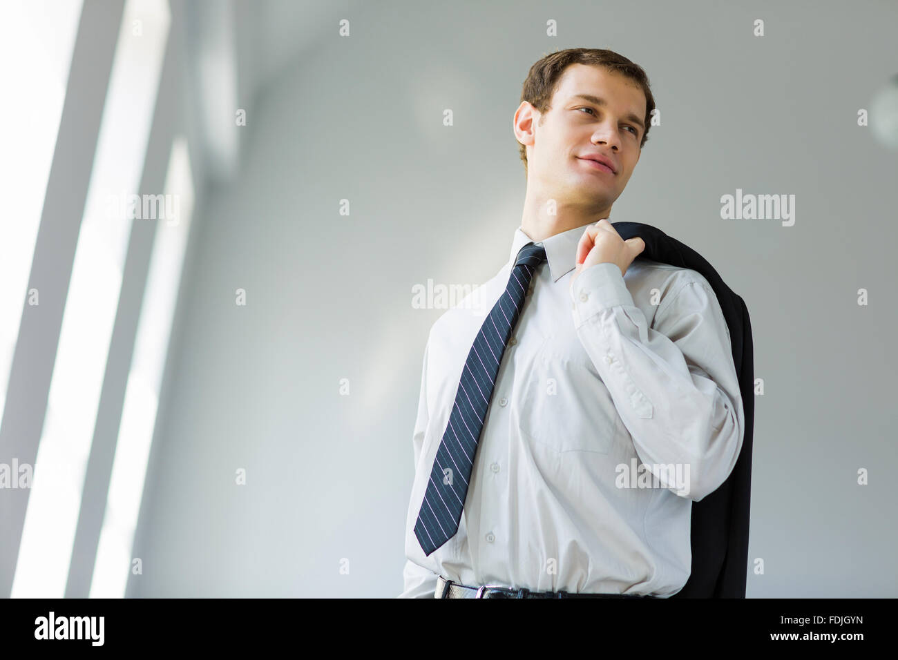 Handsome smiling businessman holding jacket on his shoulder Stock Photo ...