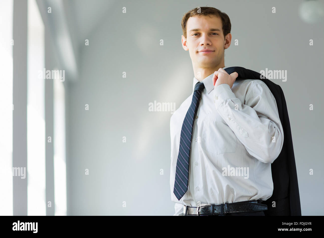 Handsome smiling businessman holding jacket on his shoulder Stock Photo ...
