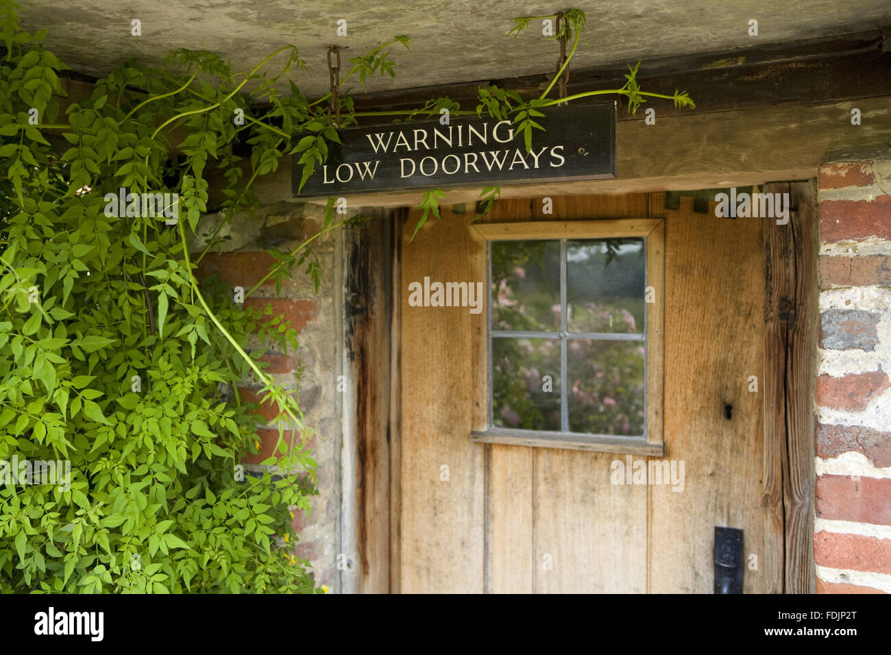 Warning sign on the low doors at Alfriston Clergy House, in East Sussex ...