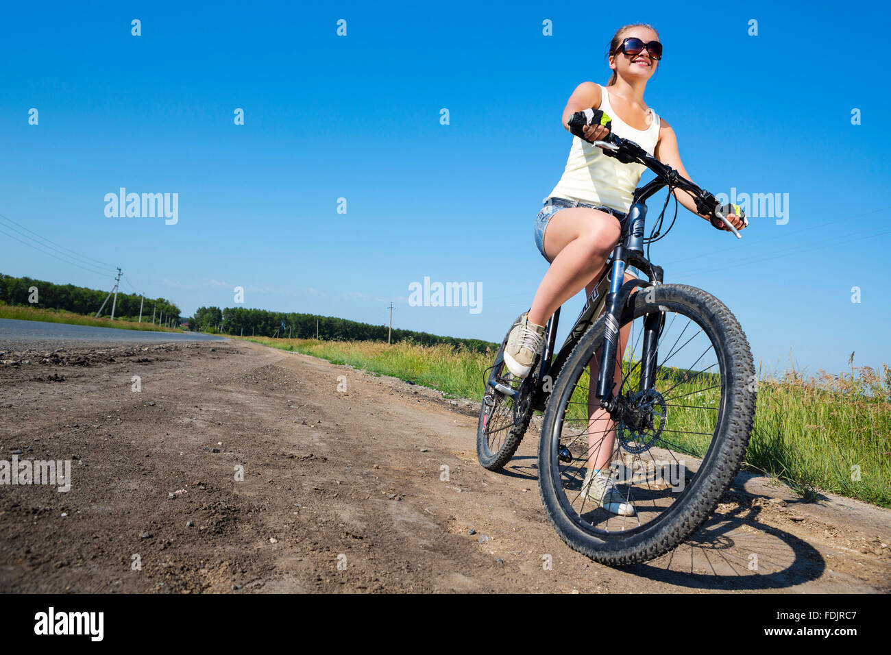 Low angle of young beautiful woman riding a bicycle in a park Stock ...