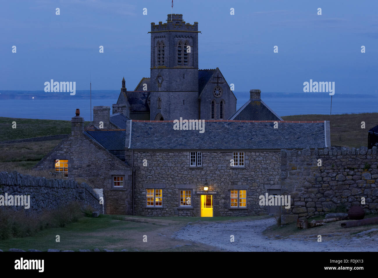 The Marisco Tavern at night with the tower of St Helena's Church behind ...