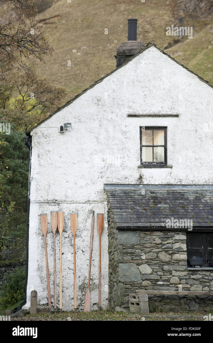 Traditional, stone-built cottage at Watendlath Tarn with wooden oars ...