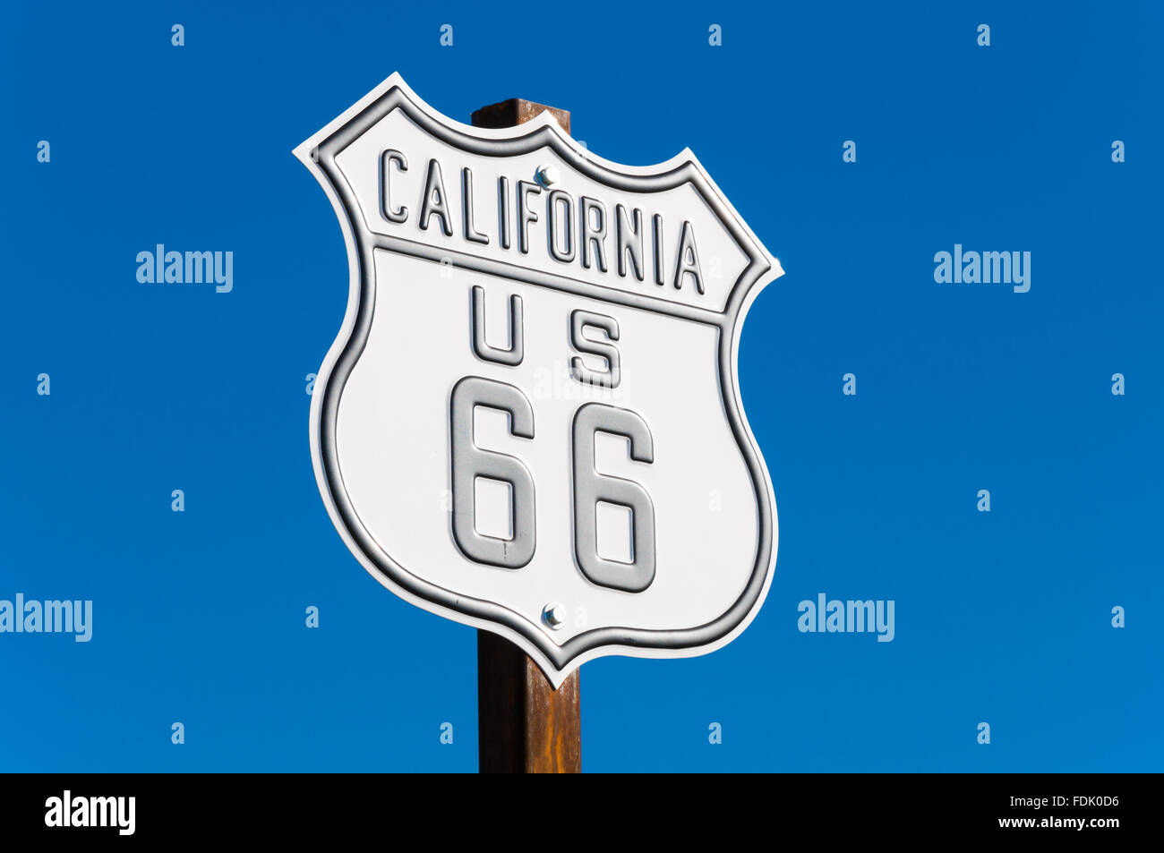 A scenic view of a historic Route 66 sign with a sky blue background ...