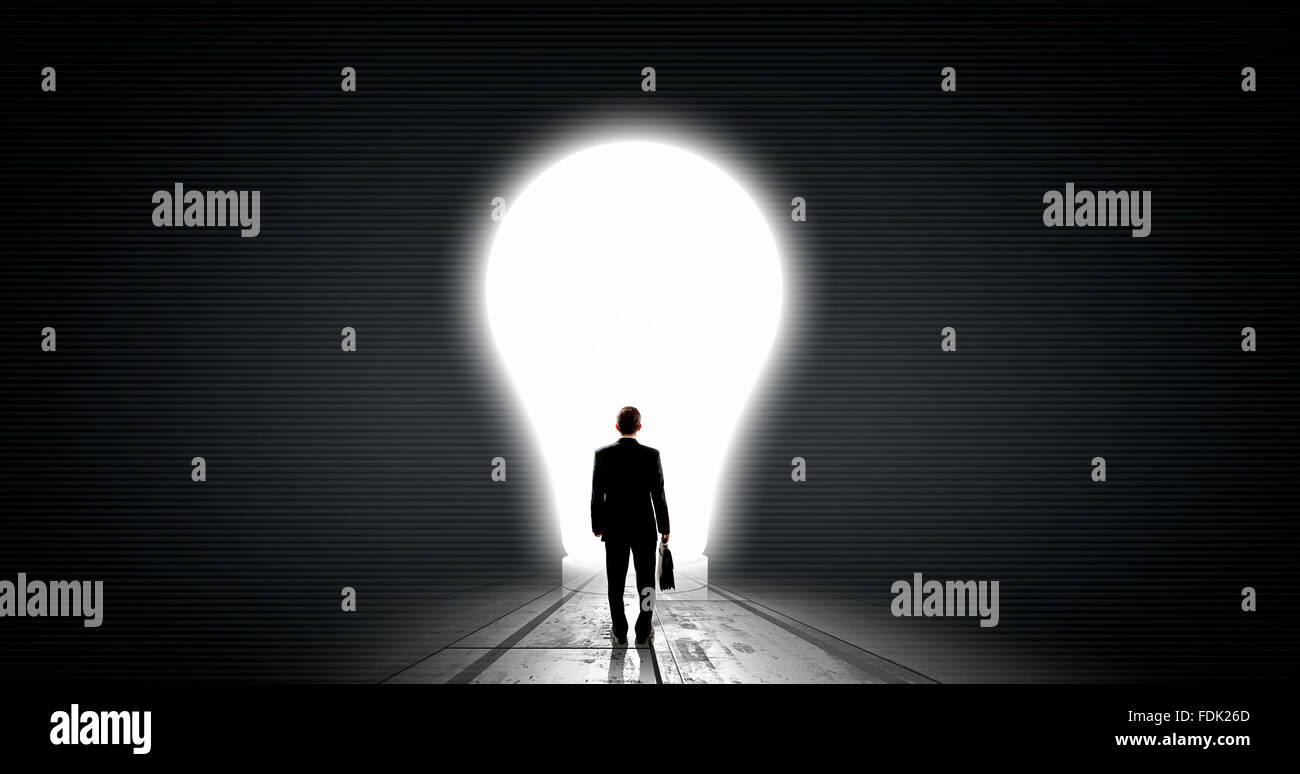 Back view of businessman looking at big glowing light bulb Stock Photo ...