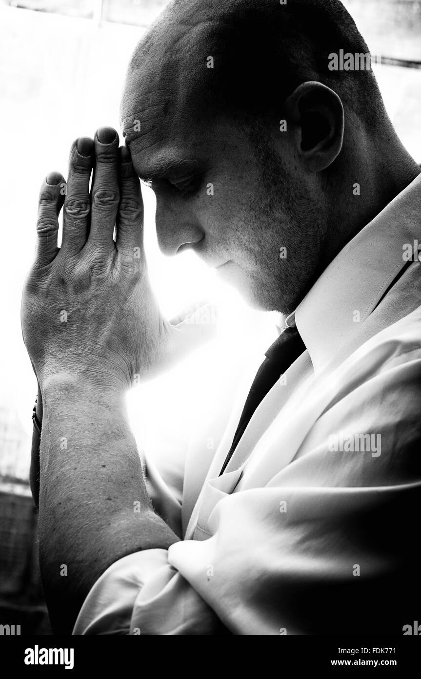 Side view of a man praying Stock Photo - Alamy