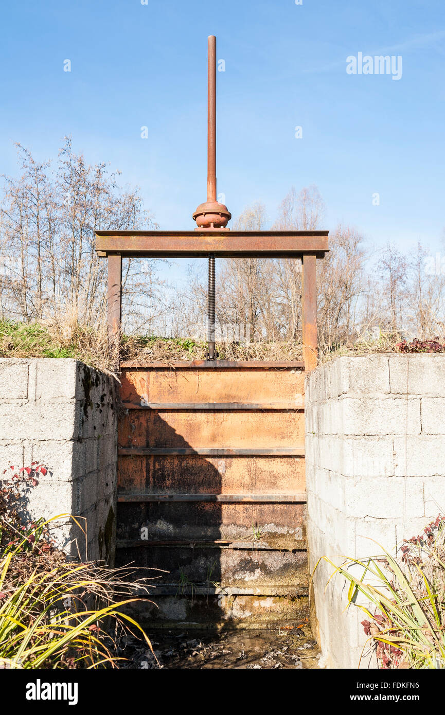 Irrigation Canal and old and manual Flood gate valve Stock Photo - Alamy