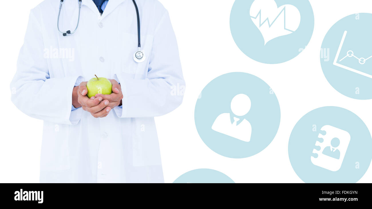 Composite image of male doctor holding green apple Stock Photo - Alamy