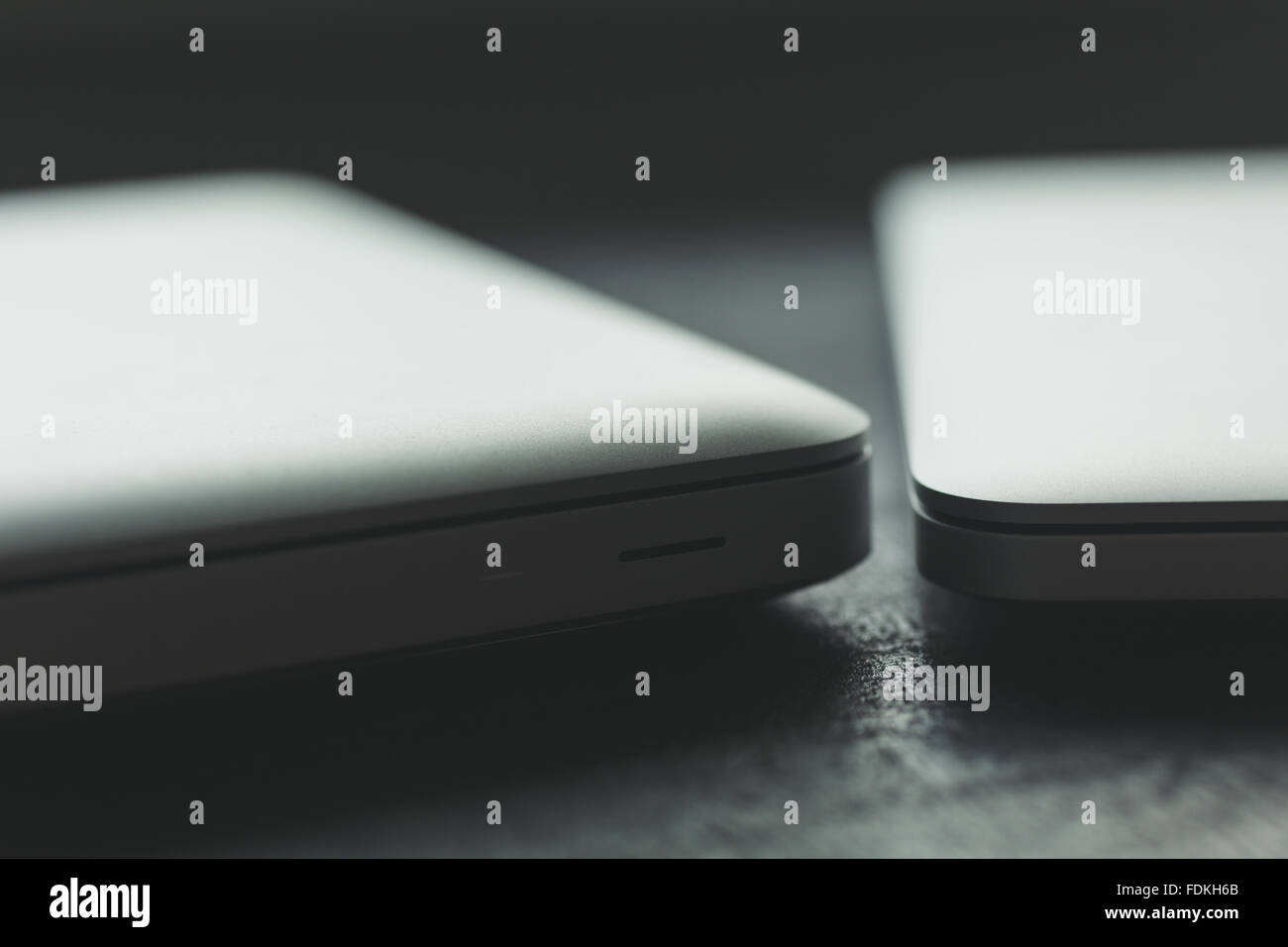 Two closed laptops on modern wooden desk Stock Photo - Alamy