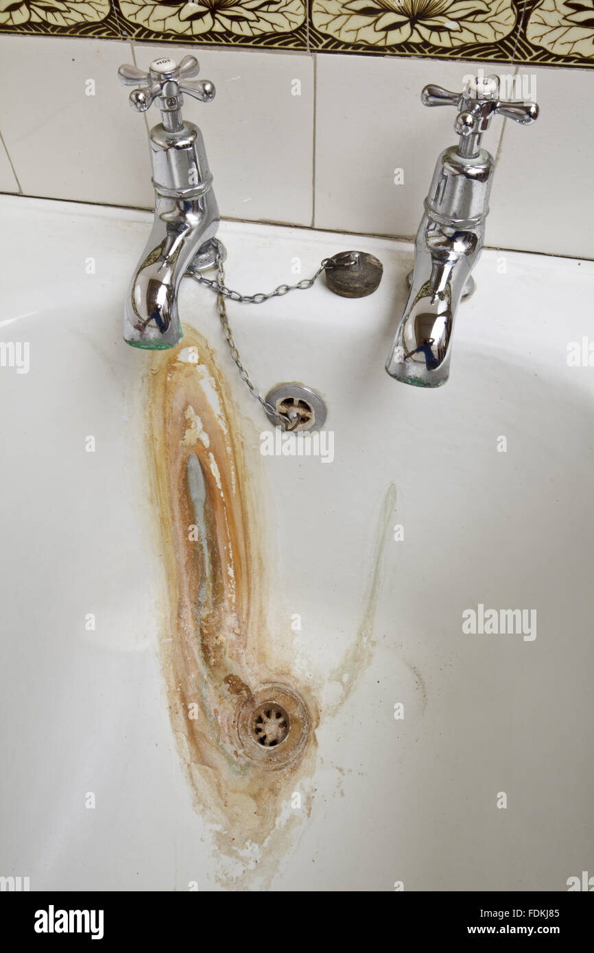 Detail of a stain in the enamel of the bath, demonstrating two supplies ...