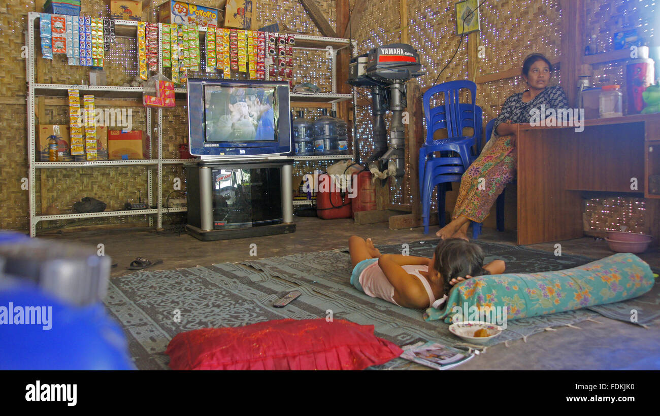 Indonesian family at home in their shop watching TV Stock Photo - Alamy