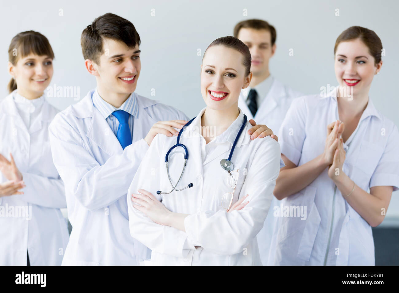 Attractive female doctor in uniform congratulated by colleagues Stock ...