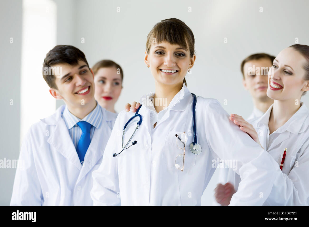 Attractive female doctor in uniform congratulated by colleagues Stock ...
