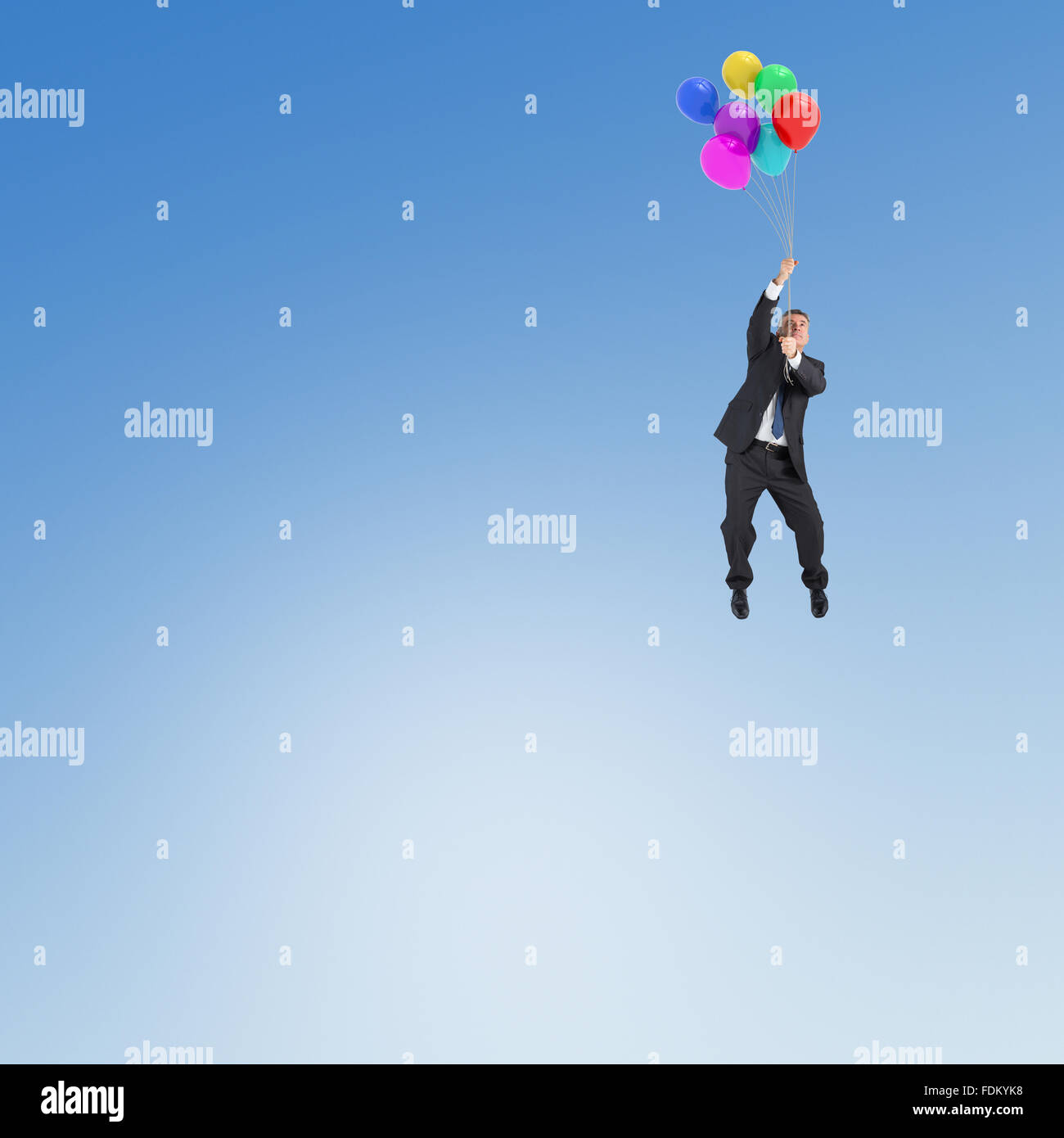 Composite image of businessman flying with balloons Stock Photo - Alamy