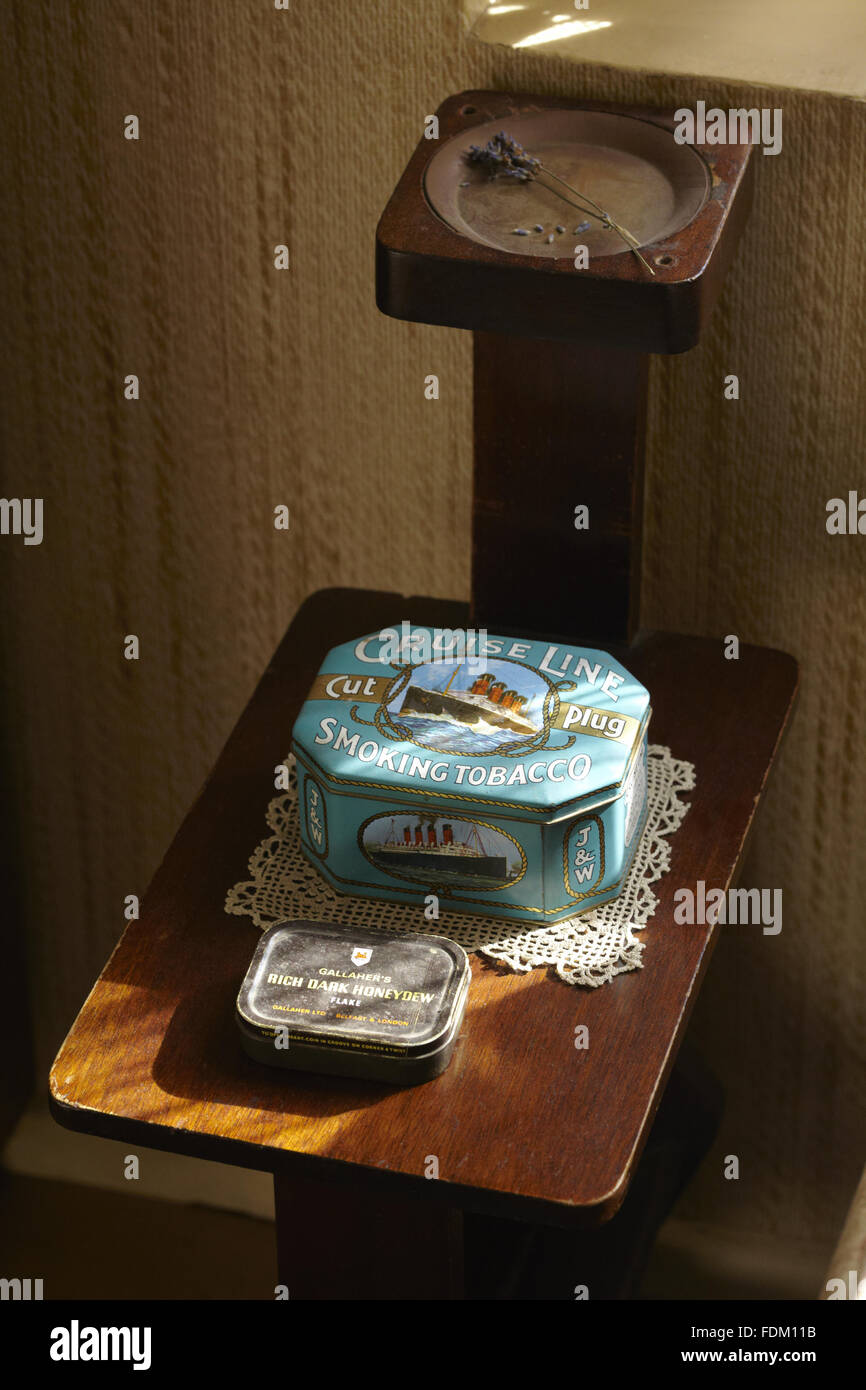 Tobacco tins on a side table stand with a brass inset ashtray at 20 ...