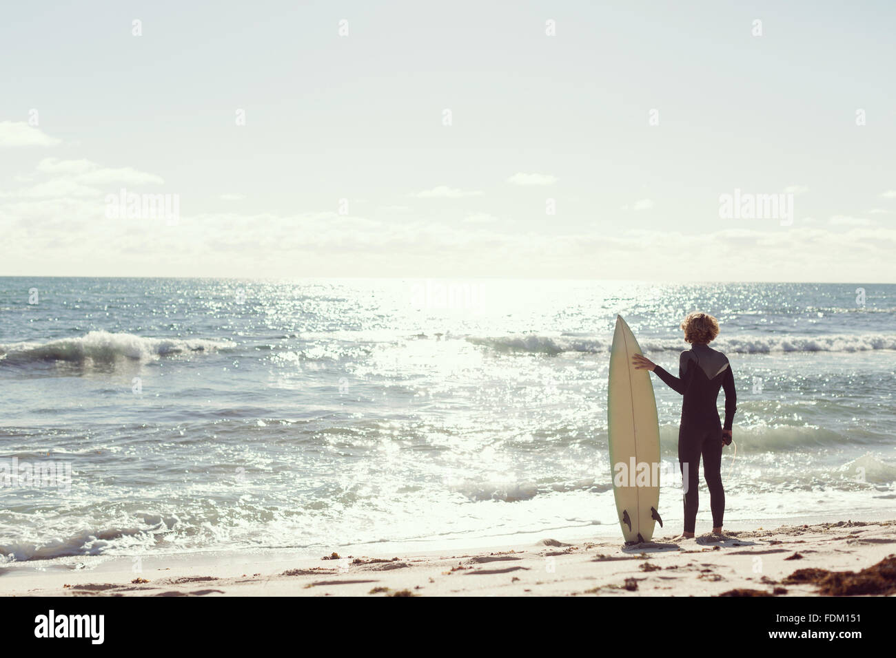 A surfer with his surfboard at the beach Stock Photo - Alamy