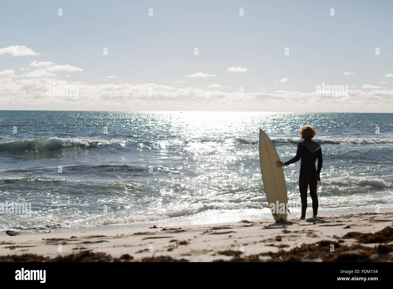 A surfer with his surfboard at the beach Stock Photo - Alamy