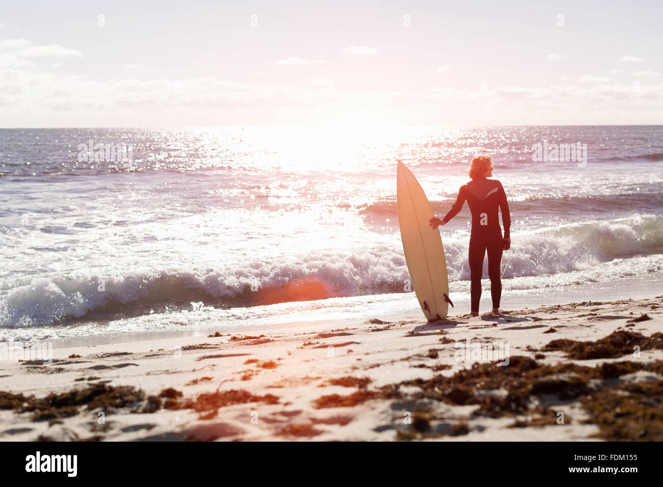 A surfer with his surfboard at the beach Stock Photo - Alamy