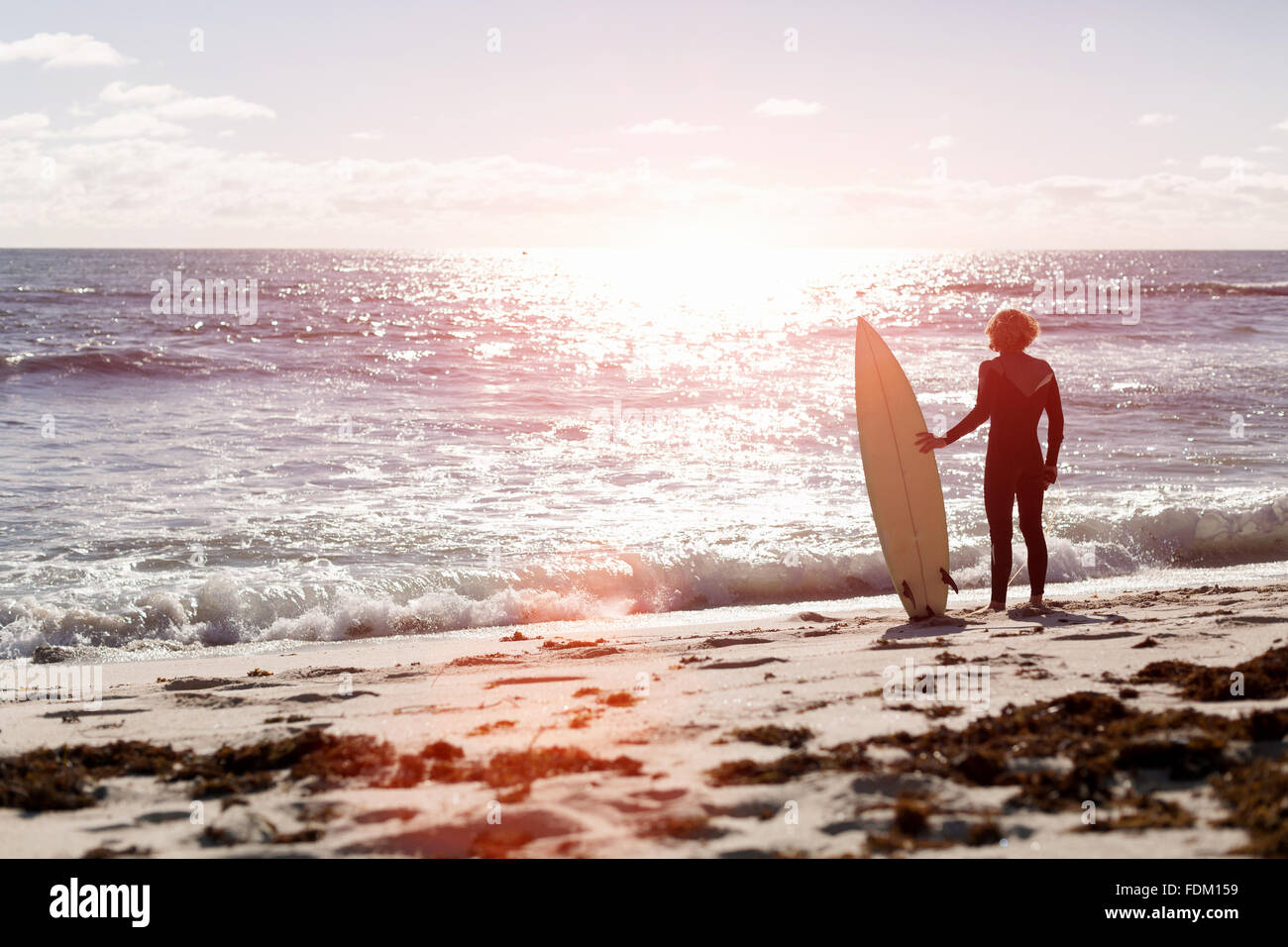 A surfer with his surfboard at the beach Stock Photo - Alamy