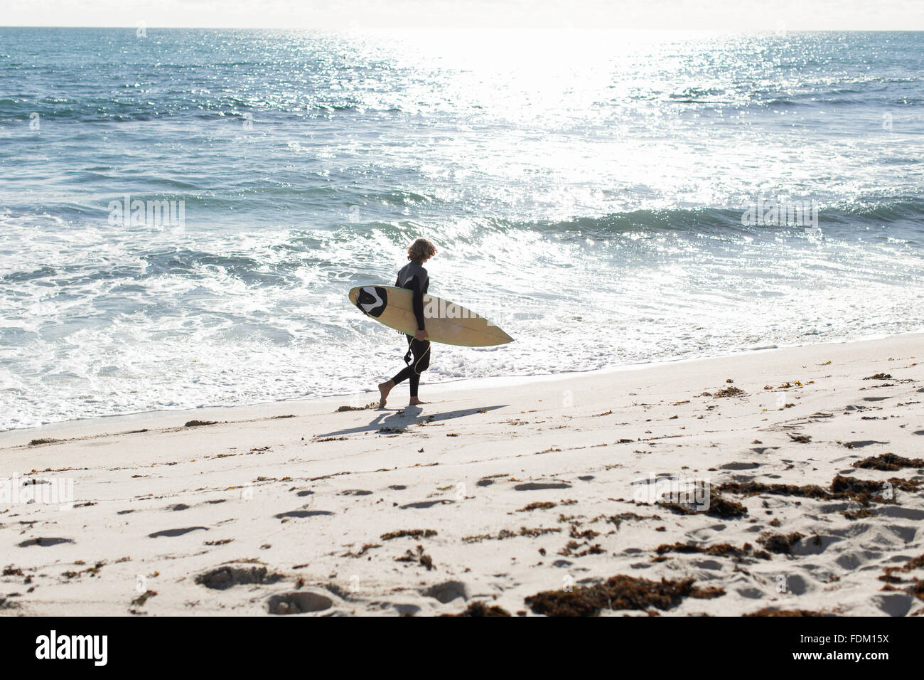 A surfer with his surfboard at the beach Stock Photo - Alamy