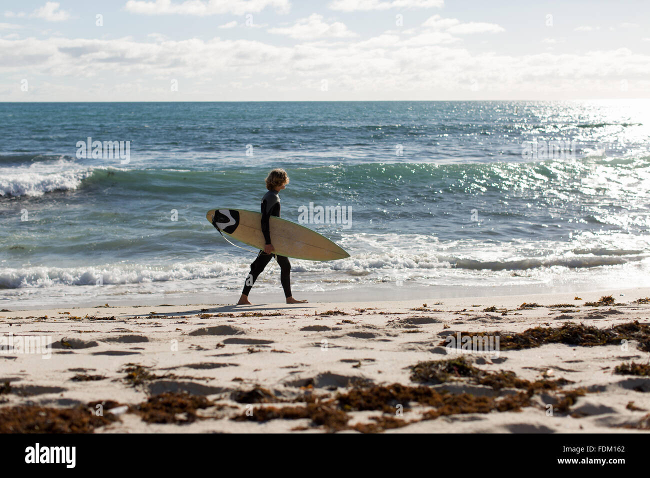 A surfer with his surfboard at the beach Stock Photo - Alamy