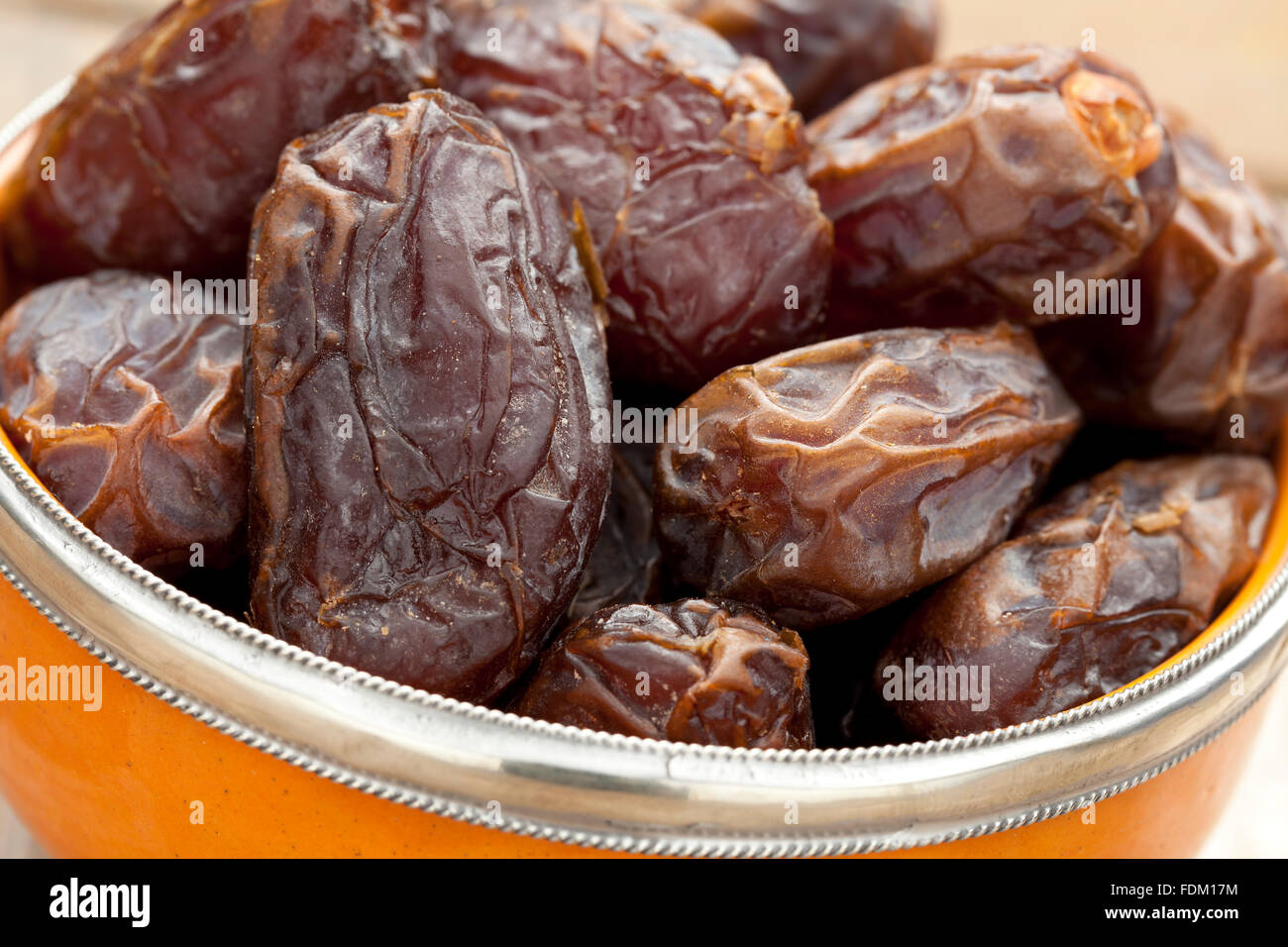 Orange bowl with dates on the table close up Stock Photo - Alamy