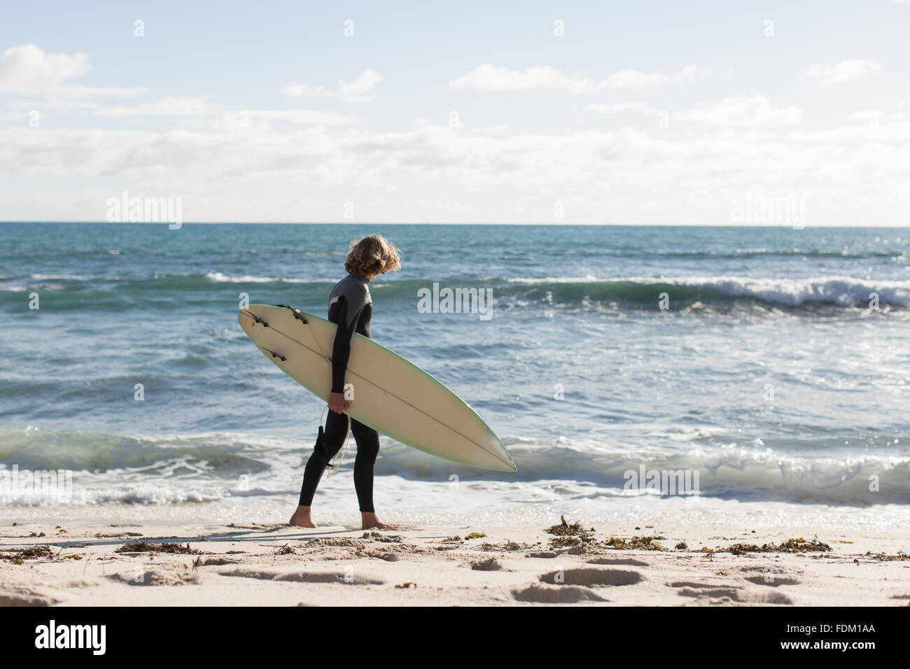 A surfer with his surfboard at the beach Stock Photo - Alamy