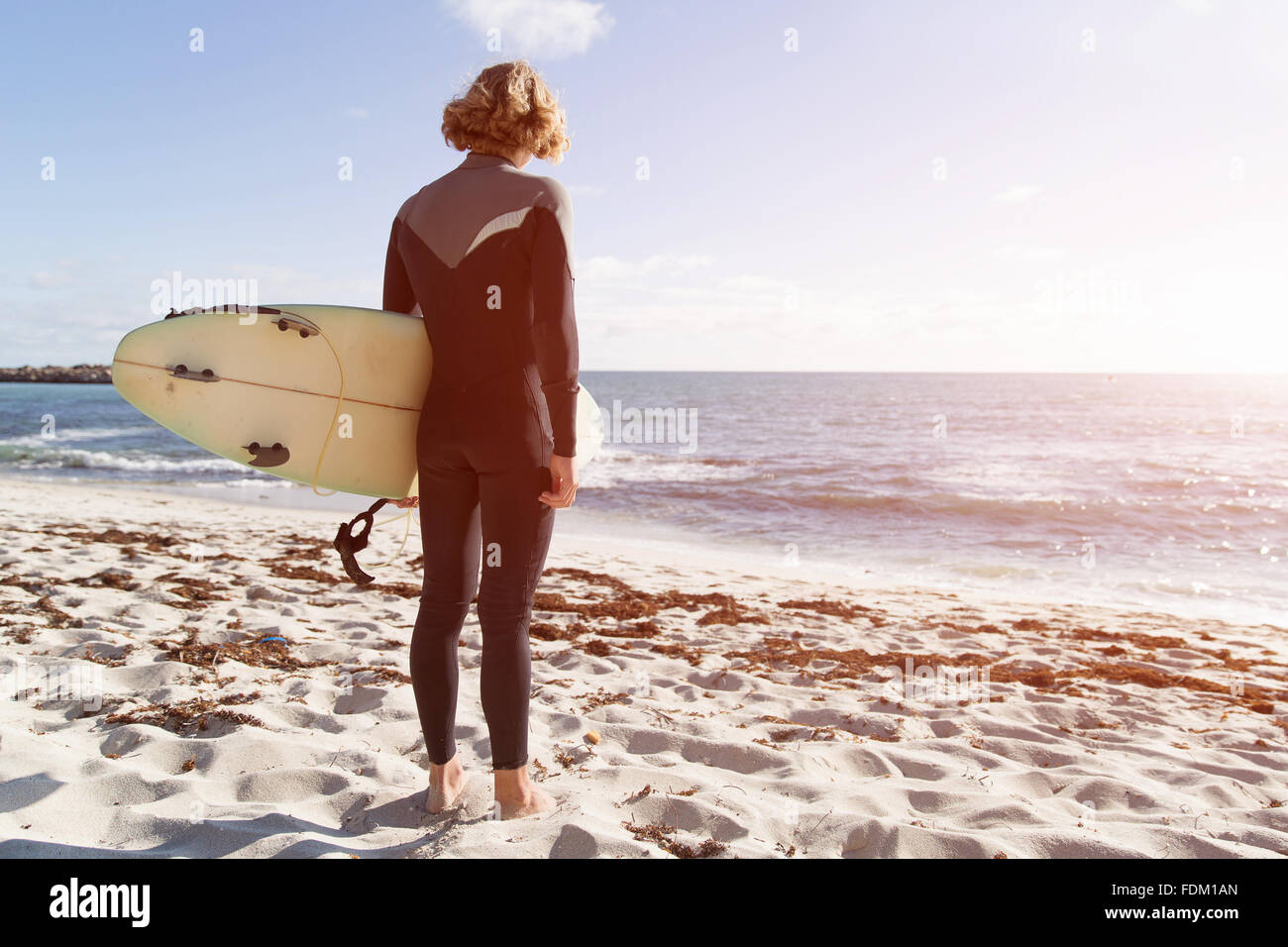 A surfer with his surfboard at the beach Stock Photo - Alamy