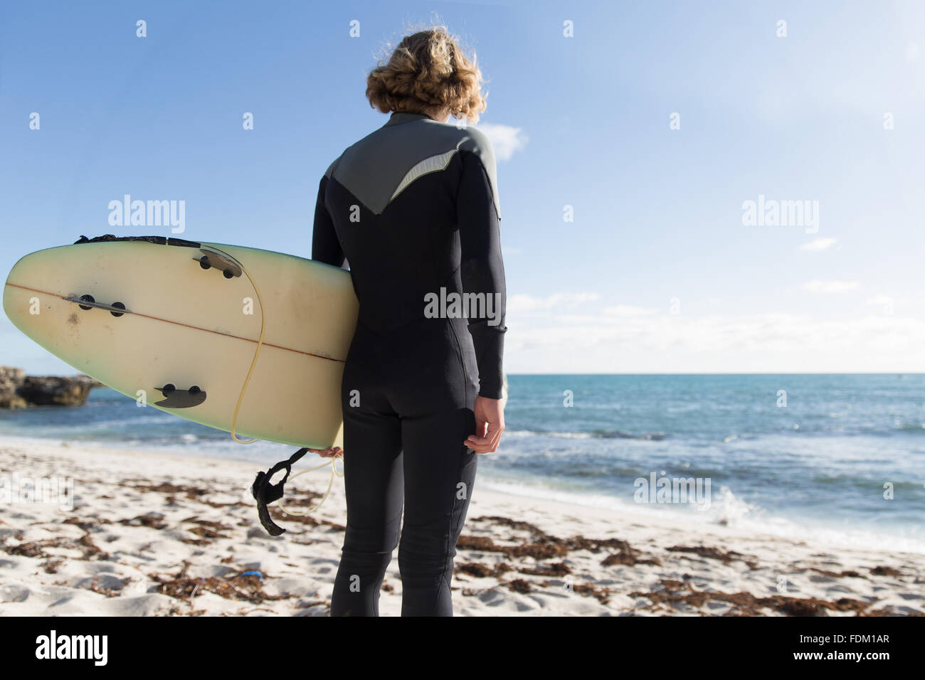 A surfer with his surfboard at the beach Stock Photo - Alamy
