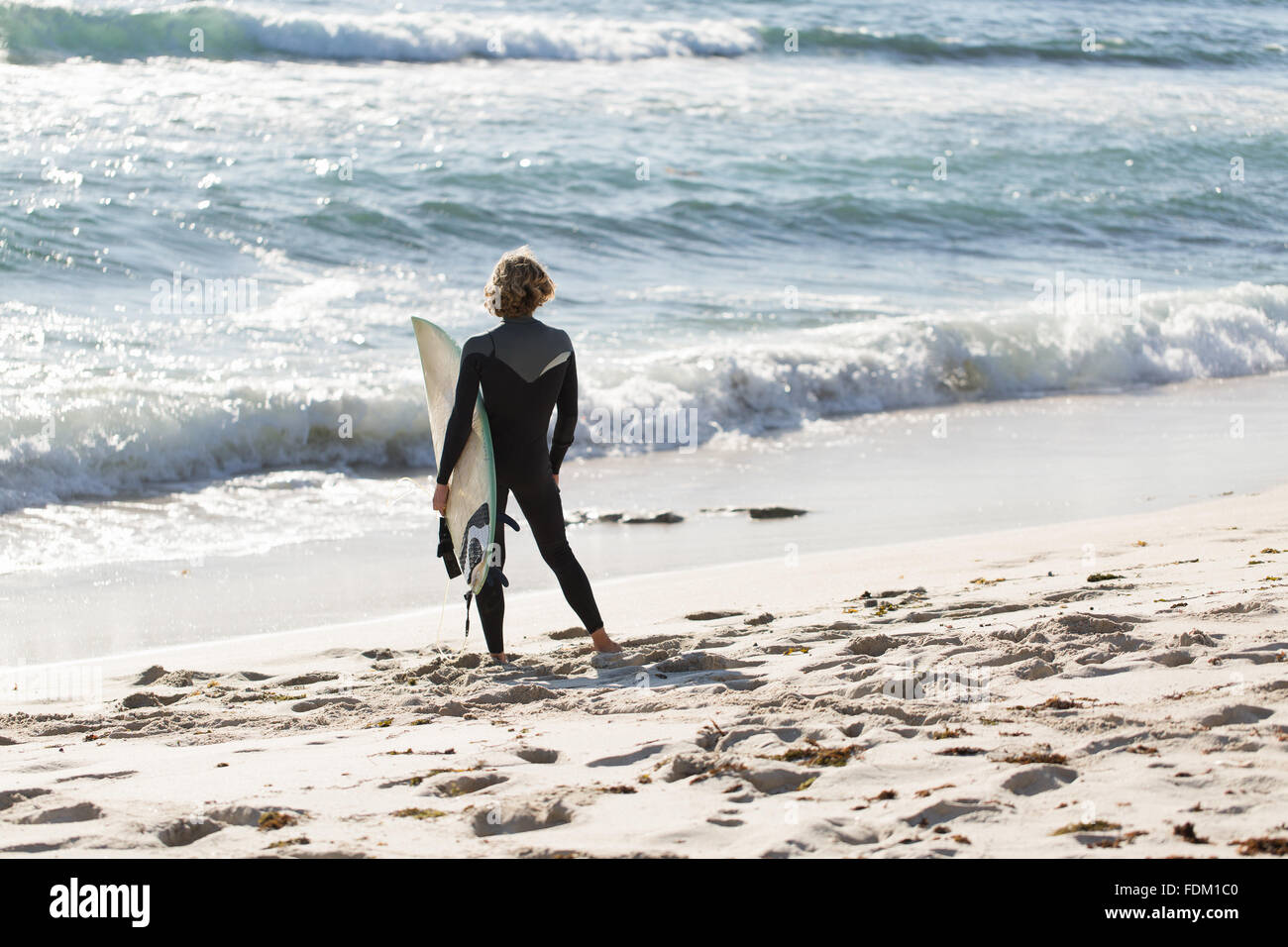 A surfer with his surfboard at the beach Stock Photo - Alamy
