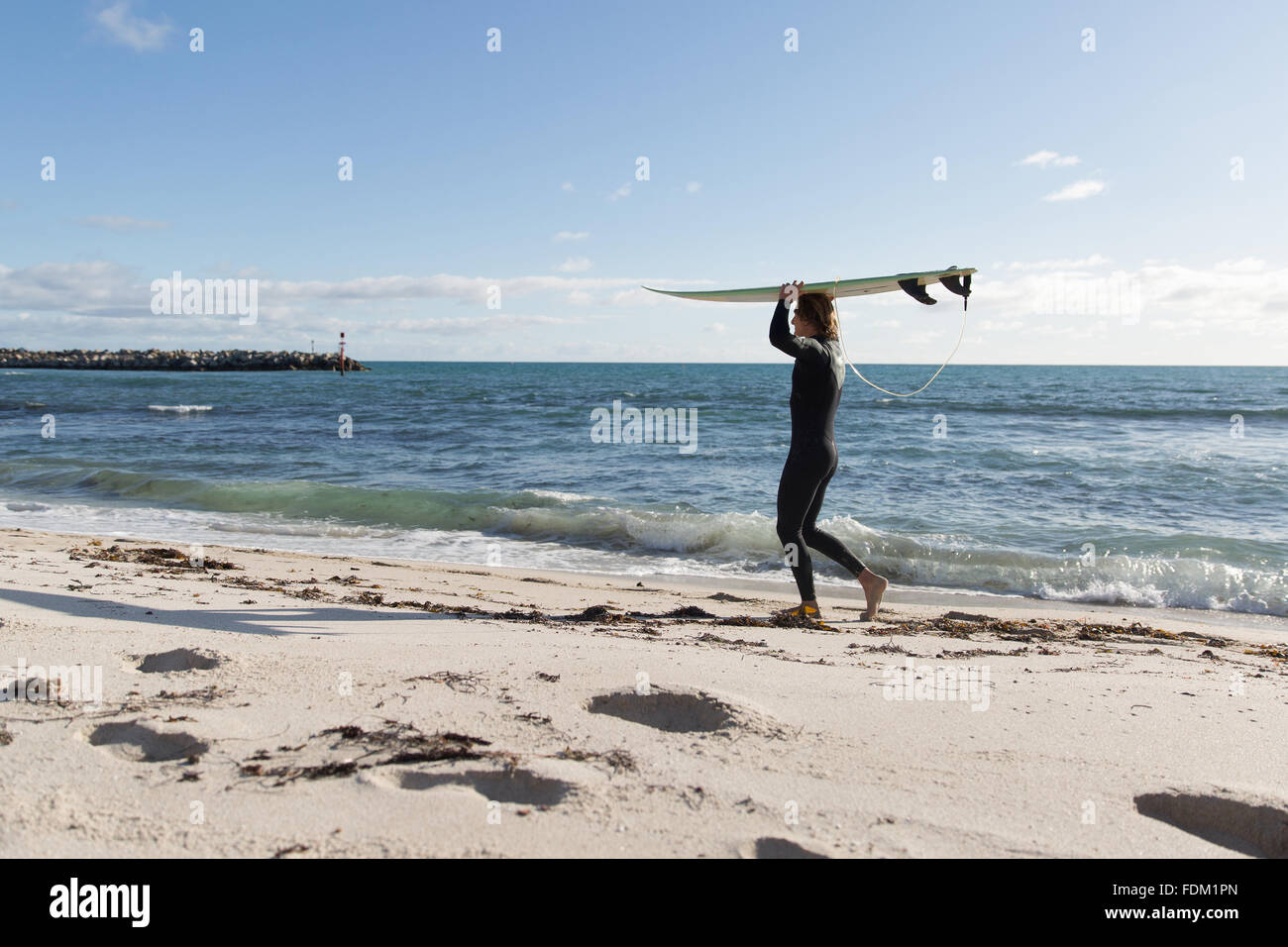 A surfer with his surfboard at the beach Stock Photo - Alamy