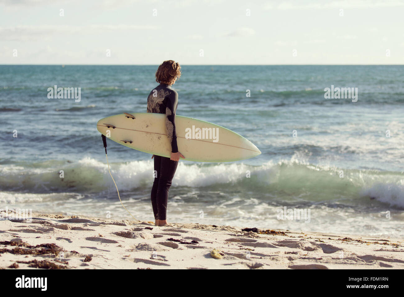 A surfer with his surfboard at the beach Stock Photo - Alamy