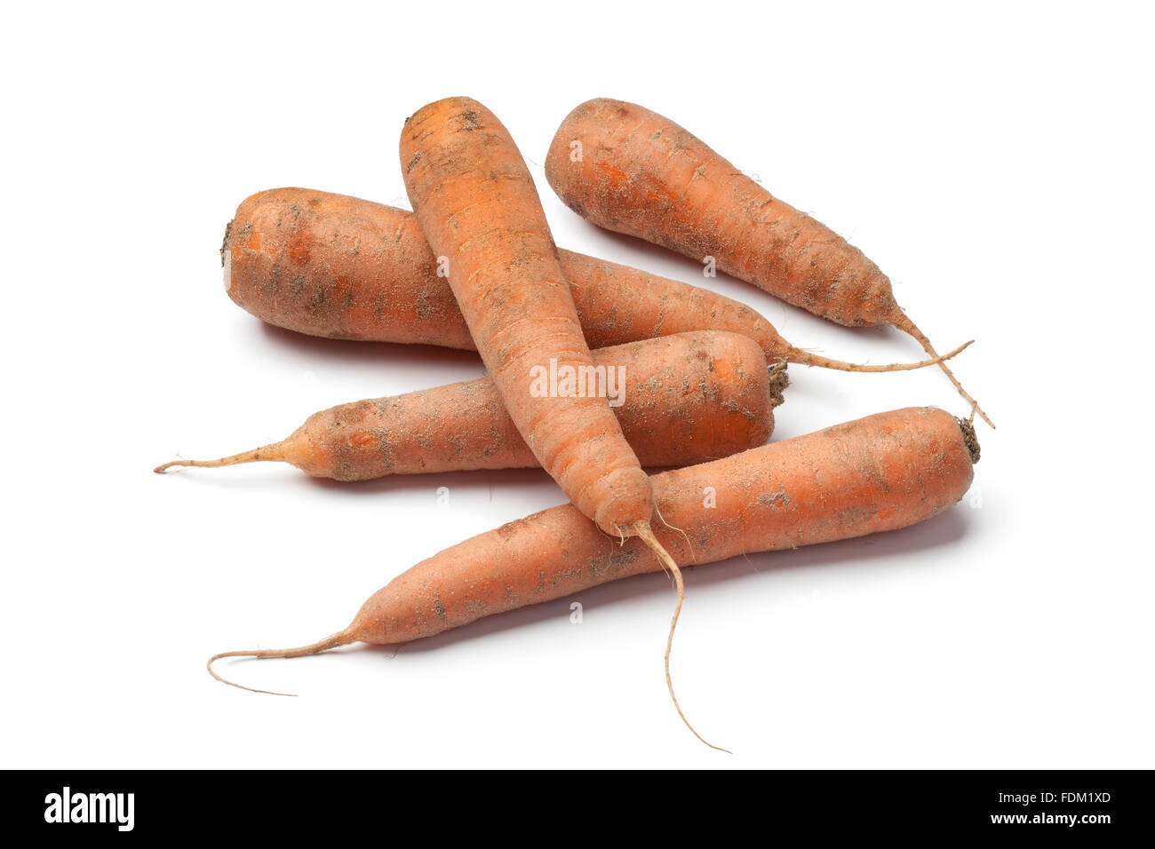 Fresh carrots with sand on white background Stock Photo - Alamy