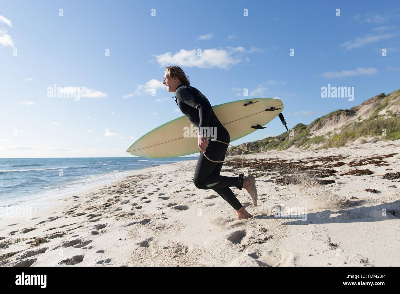A surfer with his surfboard at the beach Stock Photo - Alamy