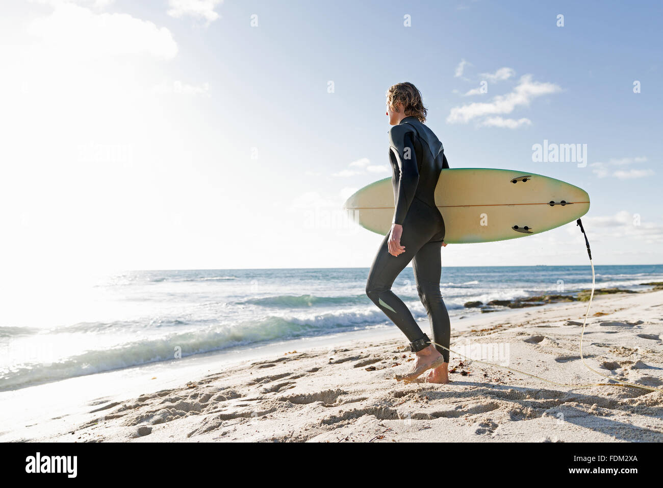 A surfer with his surfboard at the beach Stock Photo - Alamy
