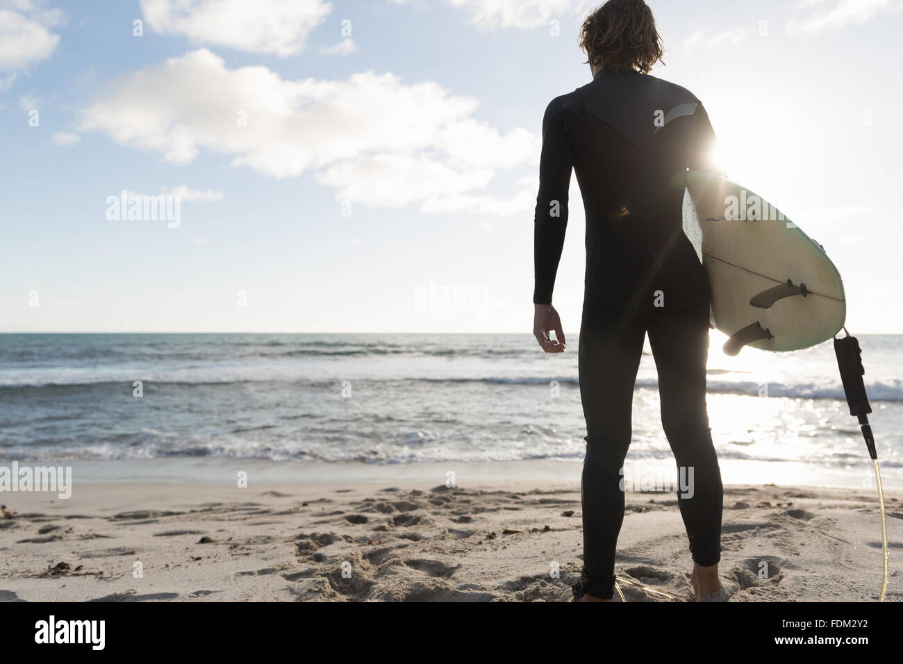 A surfer with his surfboard at the beach Stock Photo - Alamy