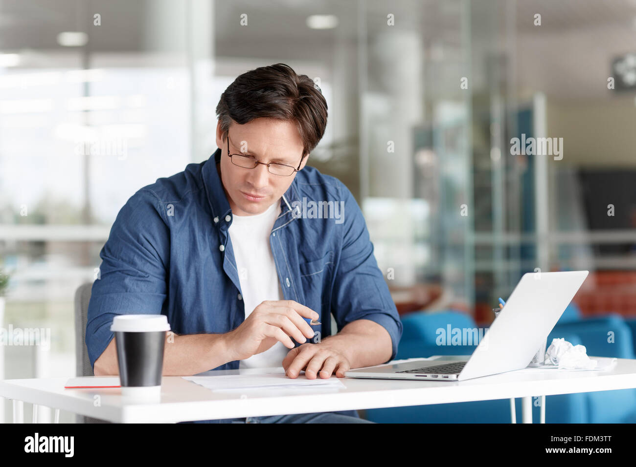 A handsome businessman working on a laptop in his office Stock Photo ...