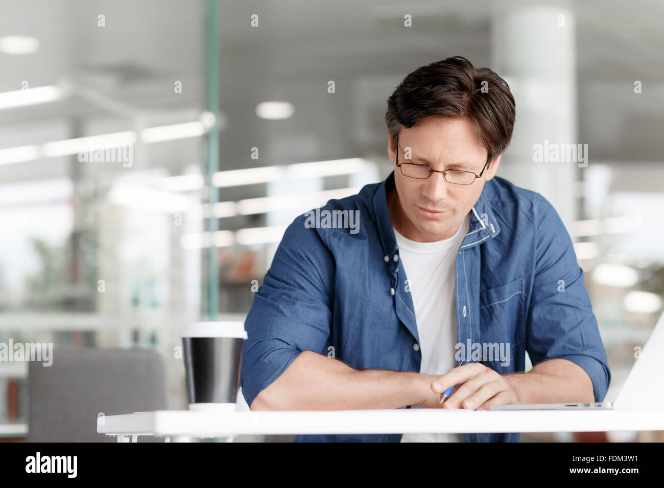 Portrait of a handsome young man in an office Stock Photo - Alamy