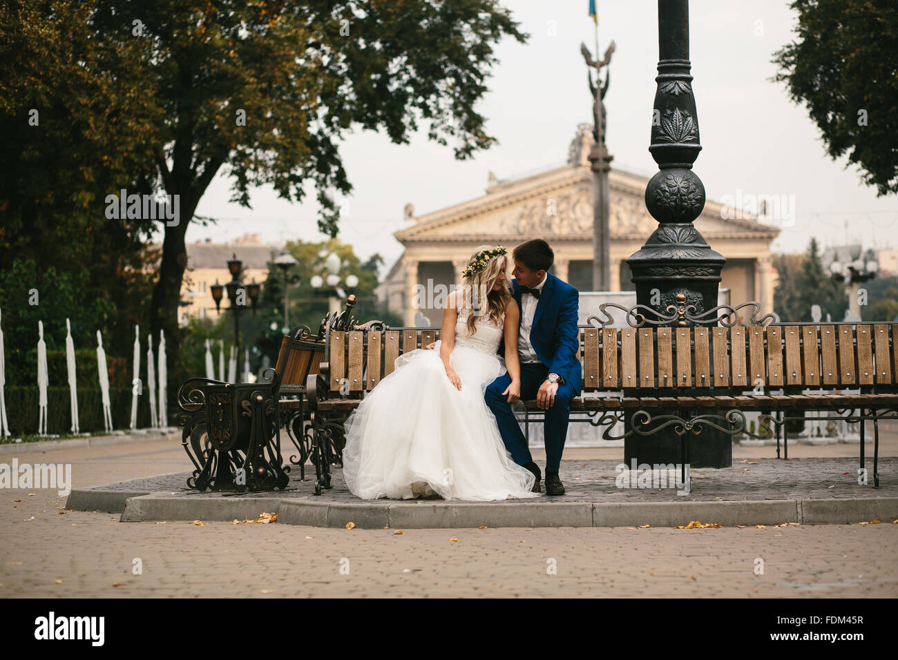 Wedding couple relaxing on a bench Stock Photo - Alamy