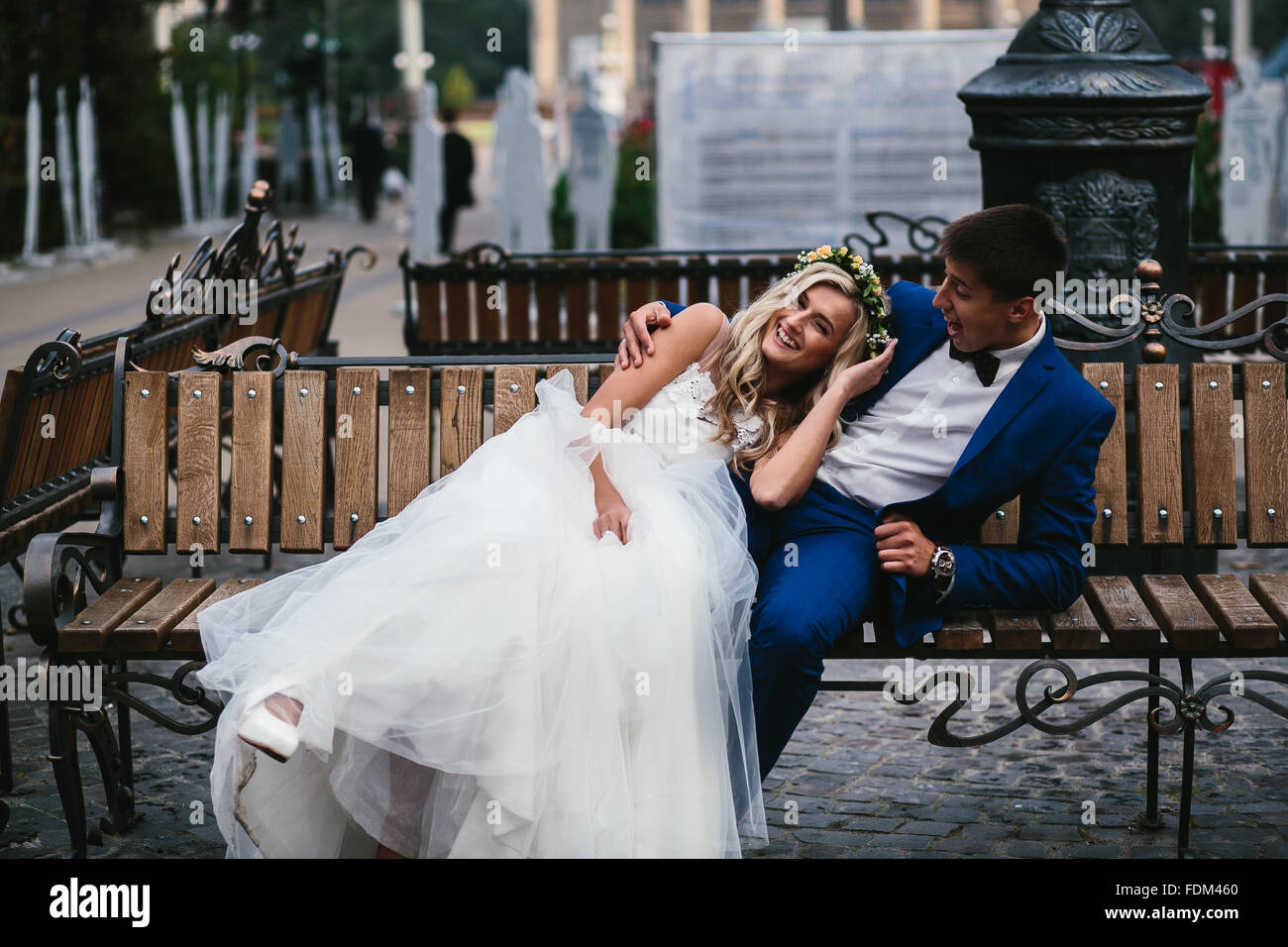 Wedding couple relaxing on a bench Stock Photo - Alamy