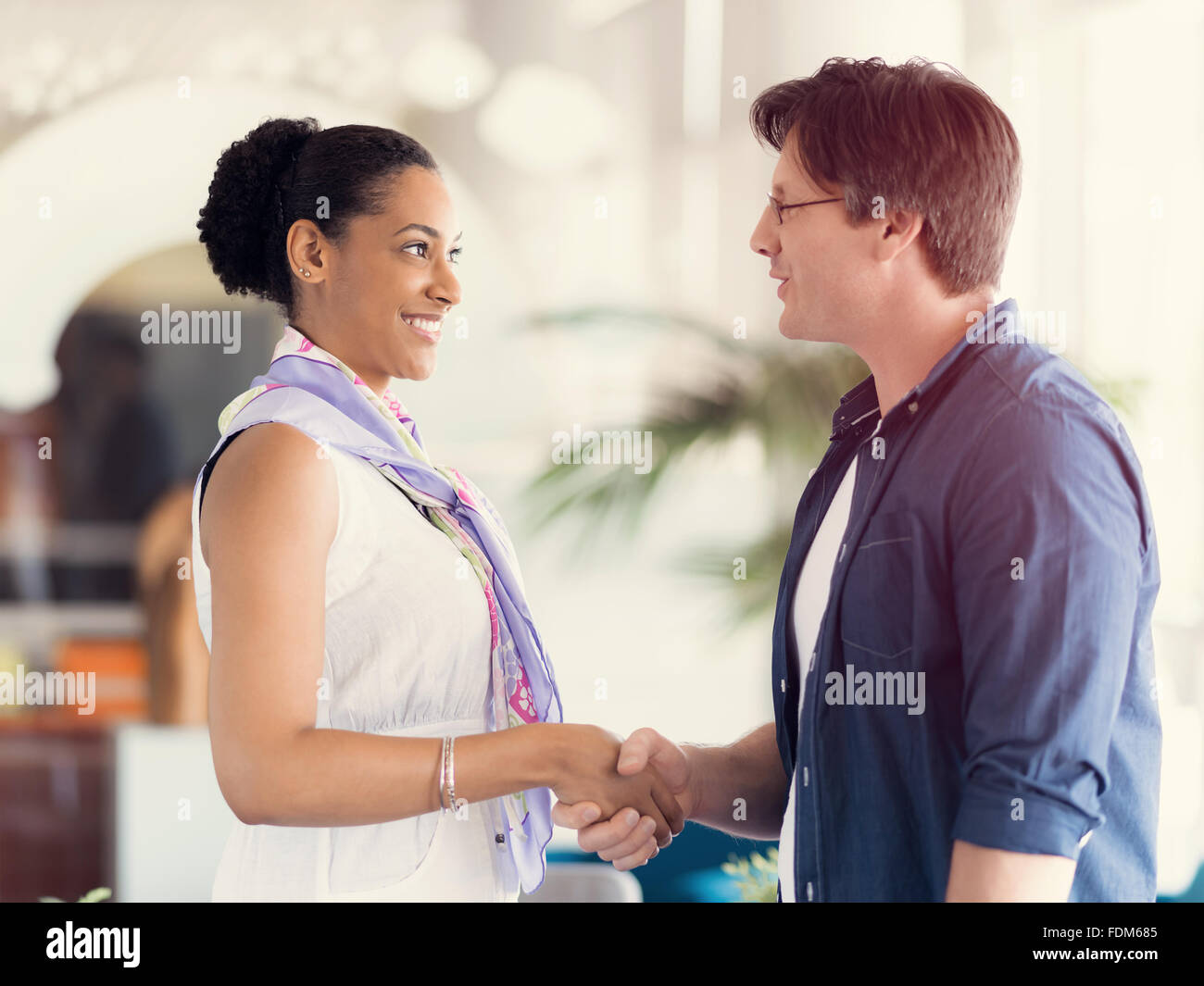 Two young professionals shaking hands Stock Photo - Alamy