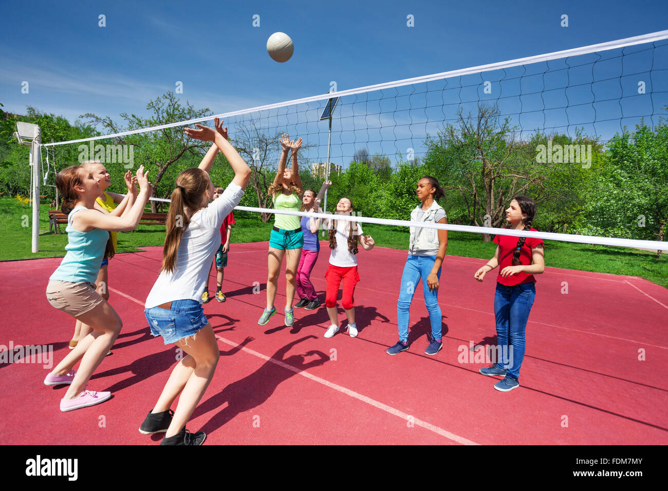 Teenage girls and boy play together volleyball Stock Photo - Alamy