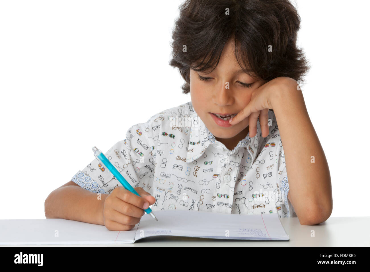 Little boy is writing in his exercise book on white background Stock ...