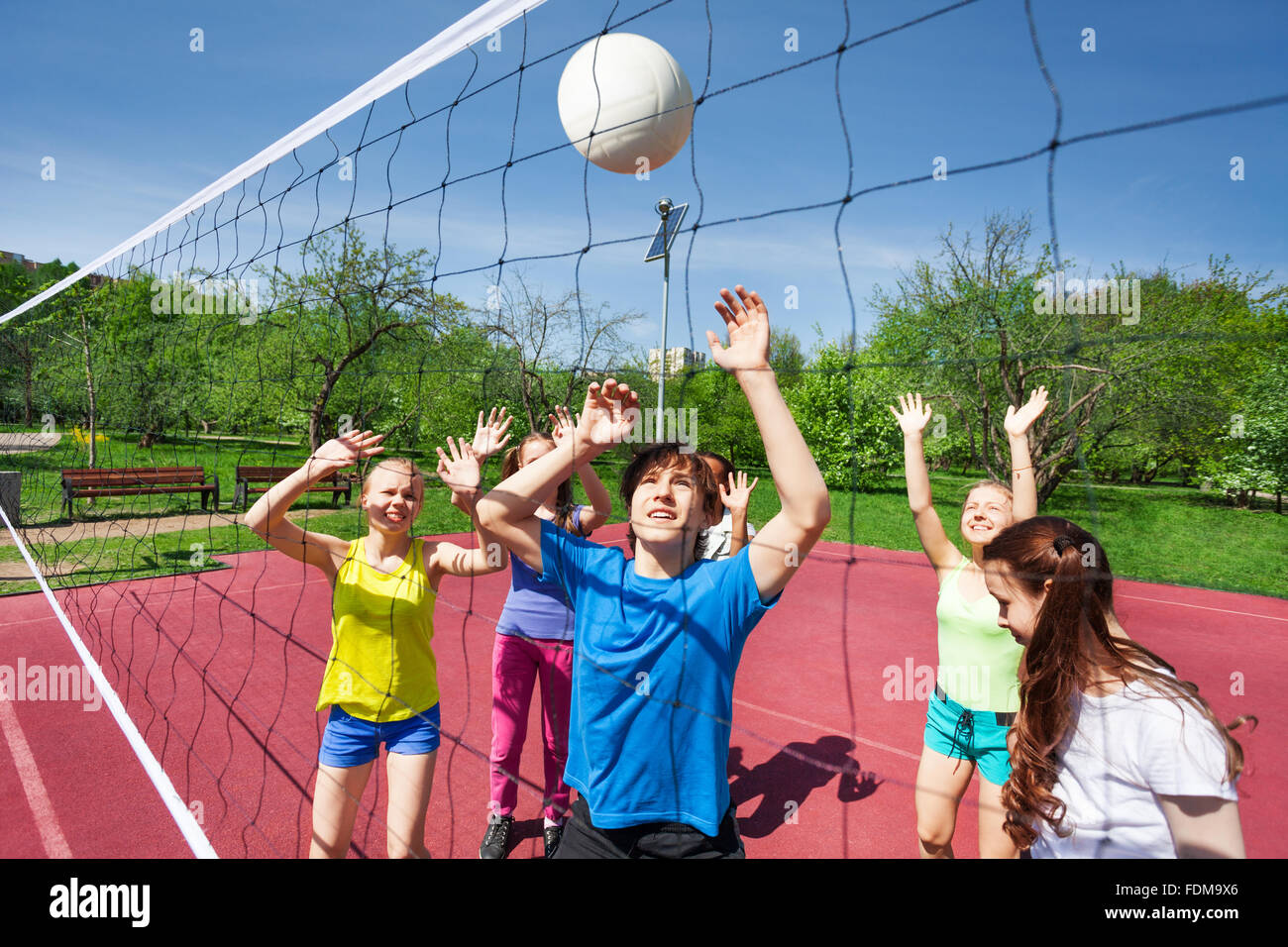 Teens in motion with arms up try to catch ball Stock Photo - Alamy