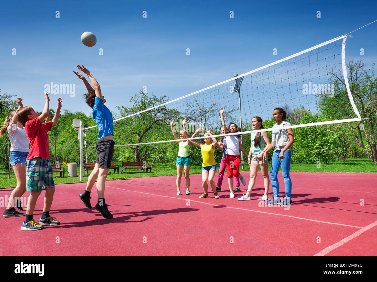 Jumping boy during volleyball game on the court Stock Photo - Alamy