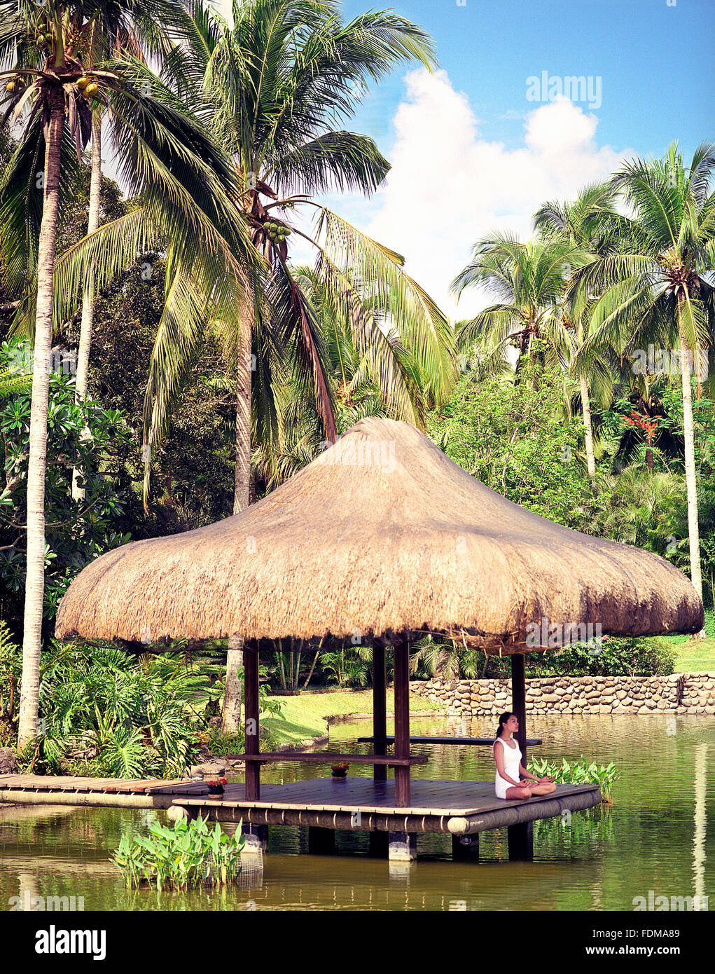 A female guest meditates under a gazebo at the Farm at San Benito. Lipa ...